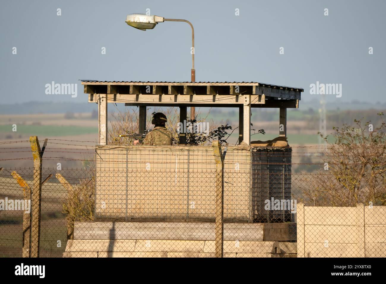 a British army soldier with an automatic rifle manning a military camp ...