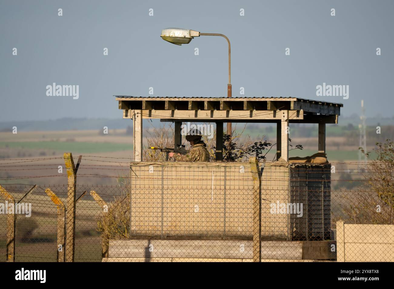 a British army soldier with an automatic rifle manning a military camp ...