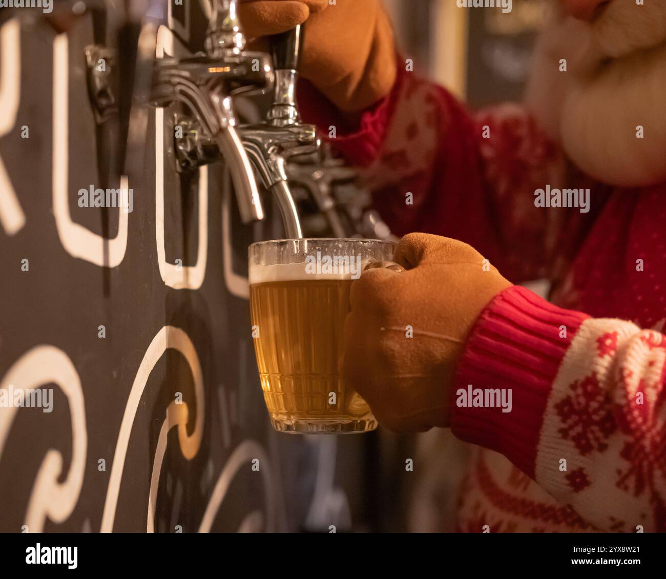Santa Claus pouring beer from a keg at a bar Stock Photo - Alamy