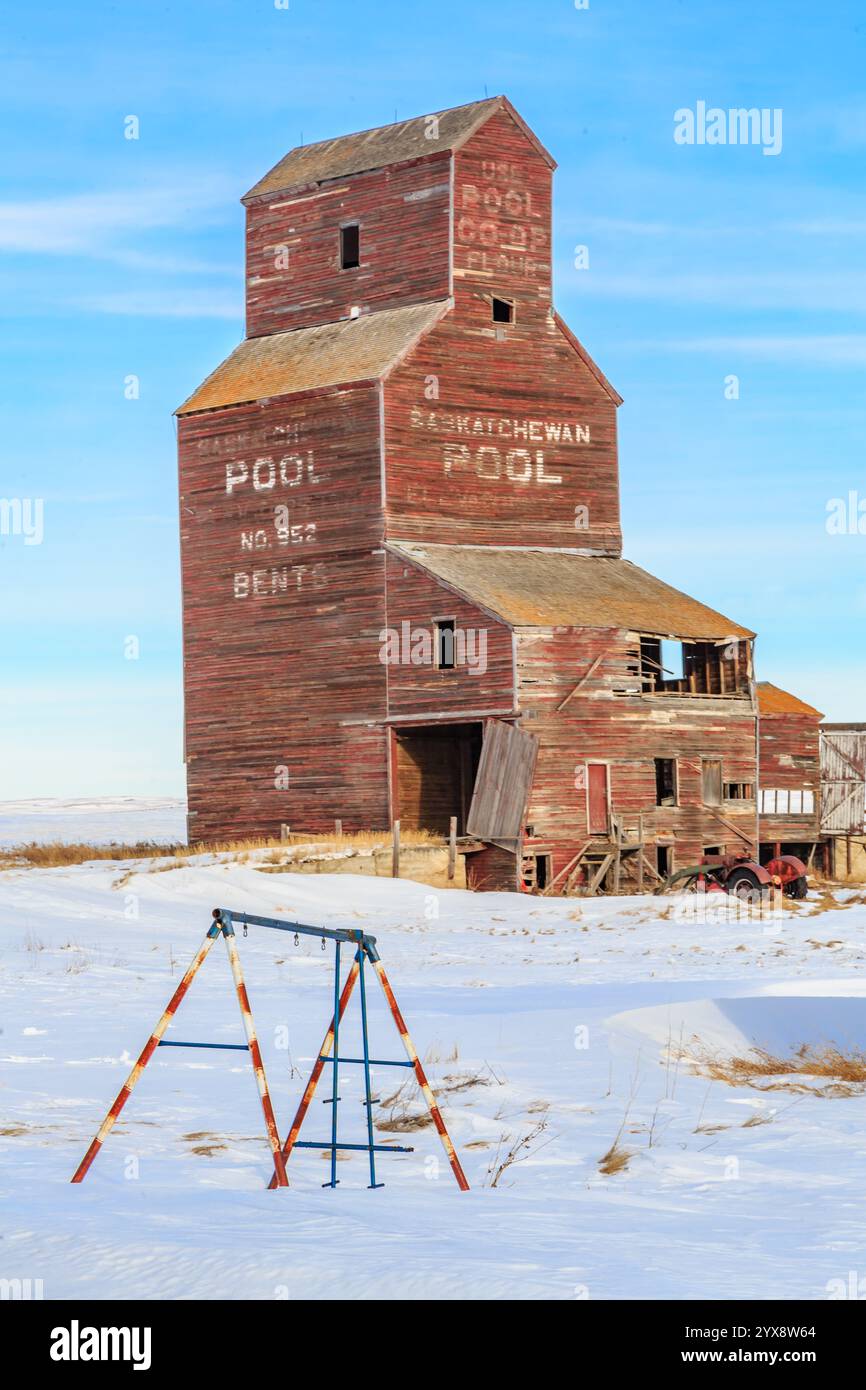 A large brown grain elevator in winter. The building is old and has a ...