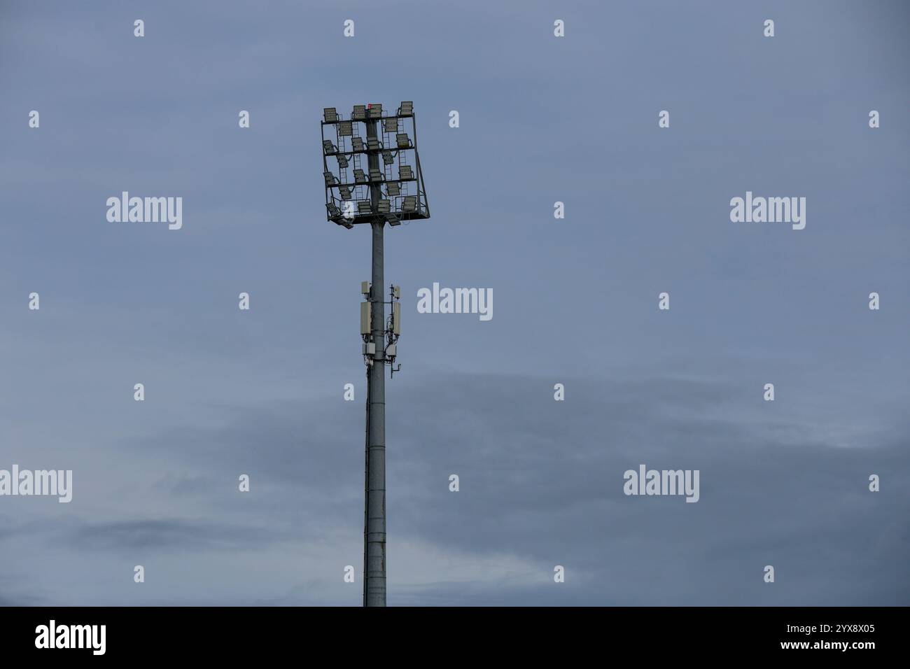 Minimalist view of a tall stadium light pole with LED lights against a ...