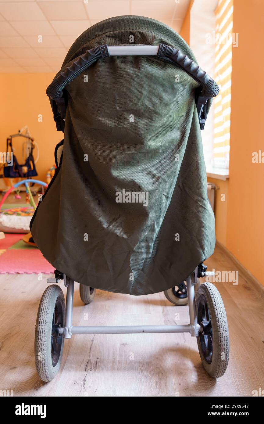 Back View of a Green Stroller in a Child-Friendly Room Stock Photo - Alamy