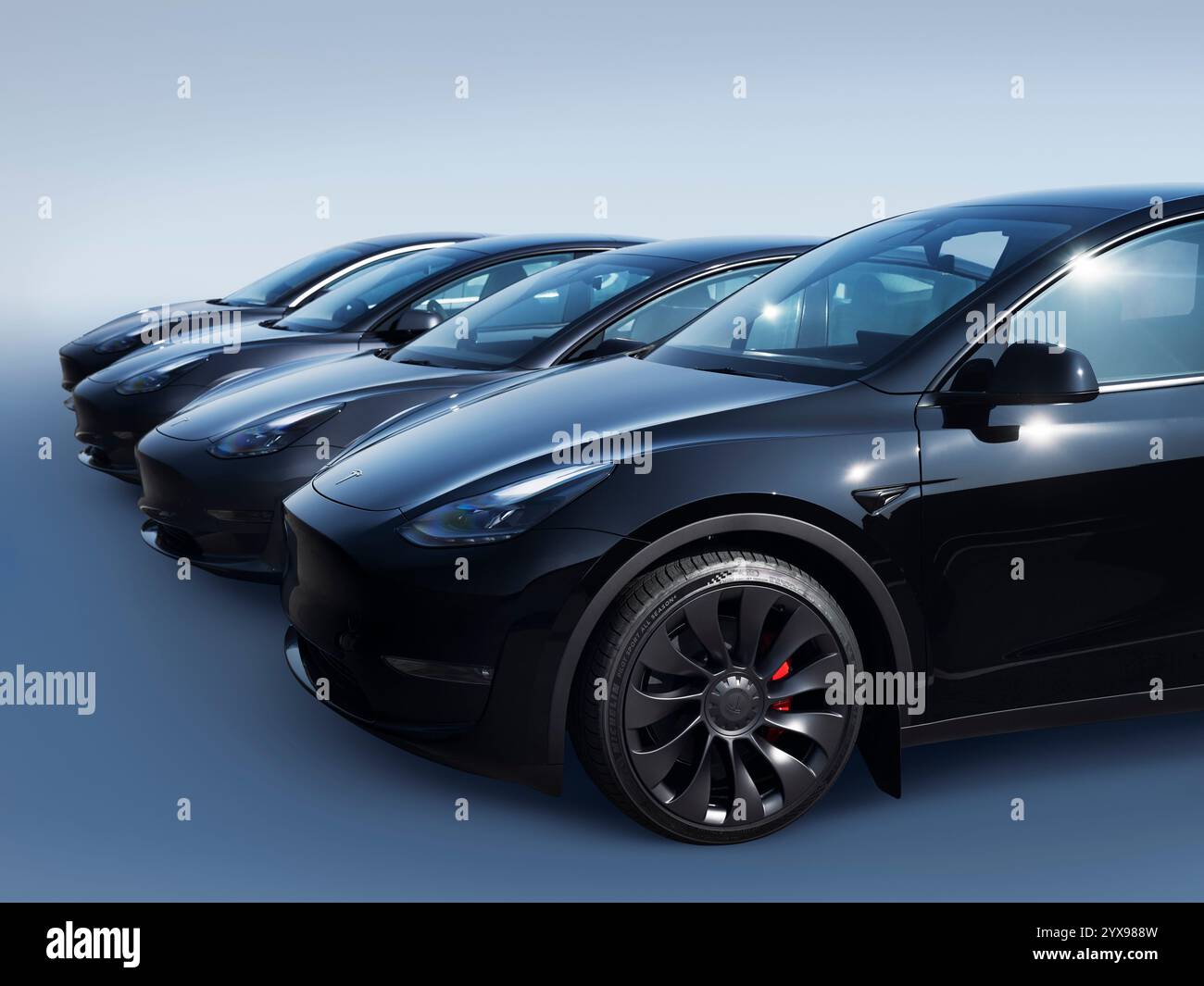 Closeup of four Tesla electric cars standing in a row. Black Tesla ...