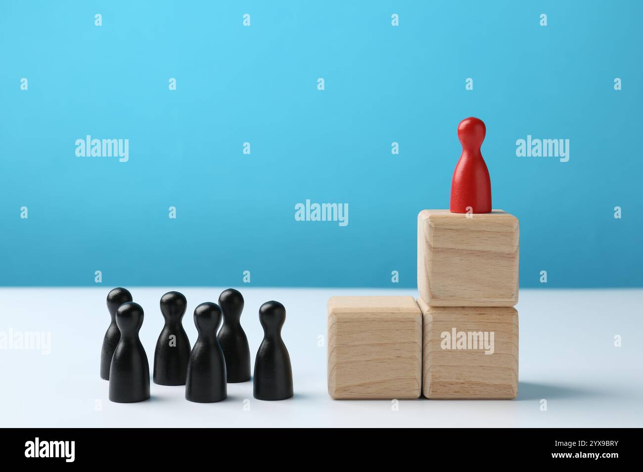Black human figures in front of stacked wooden blocks with red figure ...