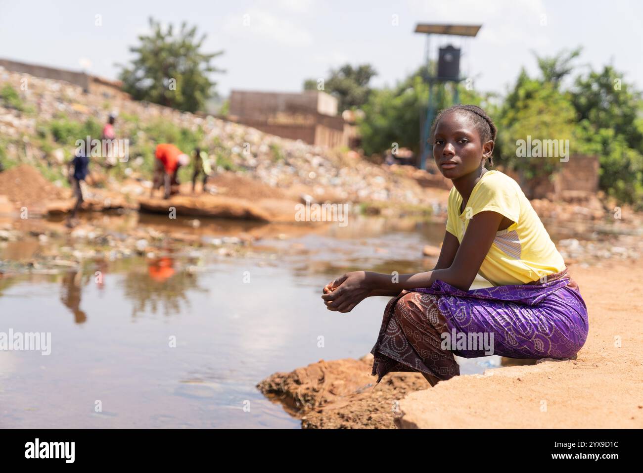 Against the backdrop of a garbage dump and dilapidated buildings, a ...