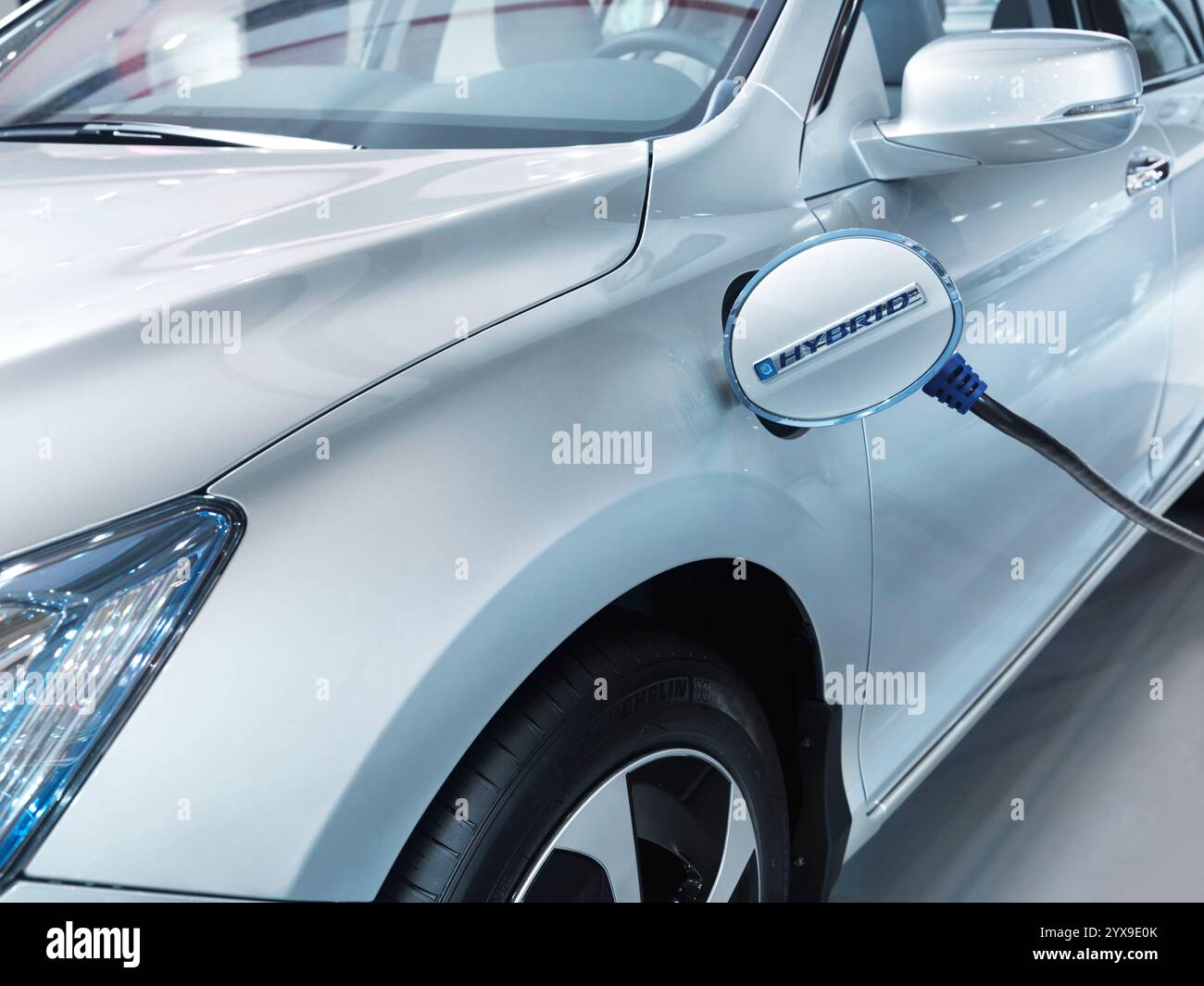 Plug-in hybrid electric vehicle recharging batteries at a charging ...