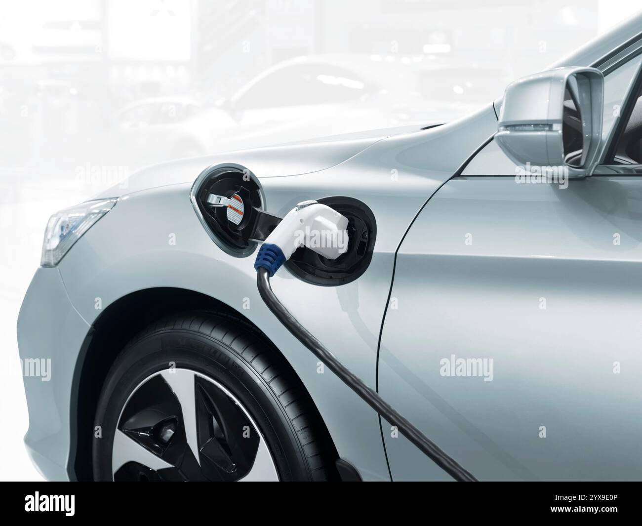 Plug-in electric car with a power cord plugged into a power socket ...