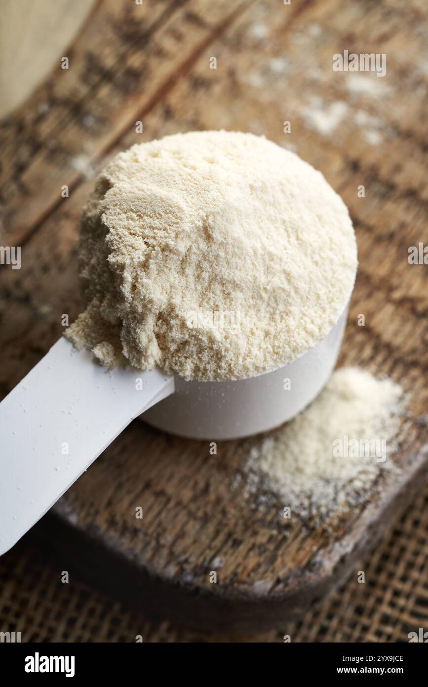 Whey protein powder in a plastic measuring cup. Healthy nutritional ...