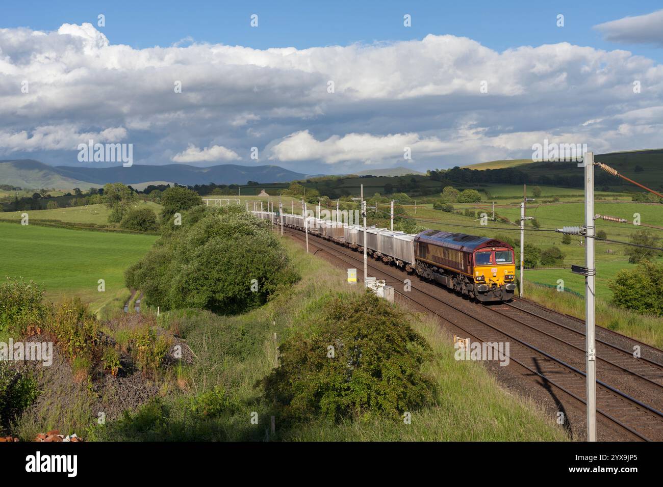 DB Cargo class 66 locomotive in EWS livery passing Docker (north of ...