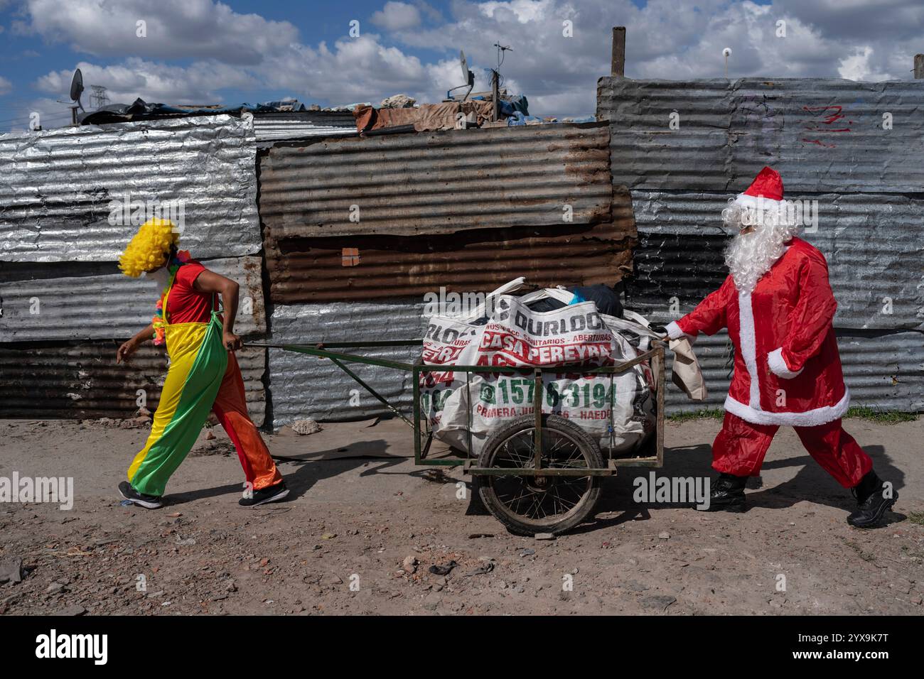 Cinthia Falcon, right, dressed as Santa Claus, pushes a cart filled ...