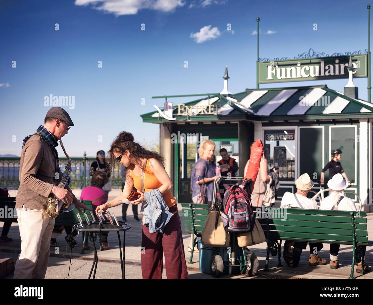 Woman tourist buying a CD of a street musician, saxophone player, by ...