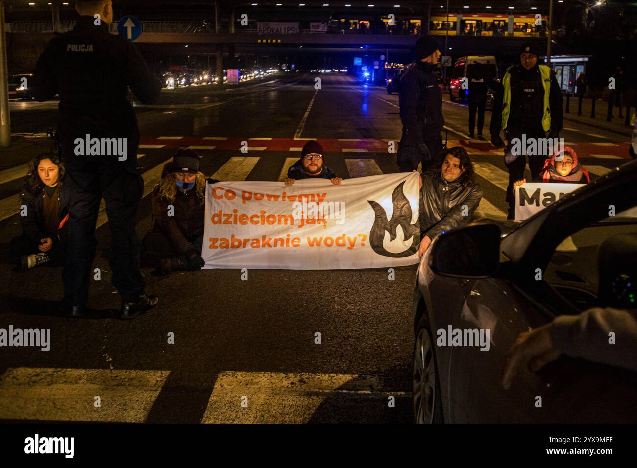 Climate activists block the road while holding a banner during the ...