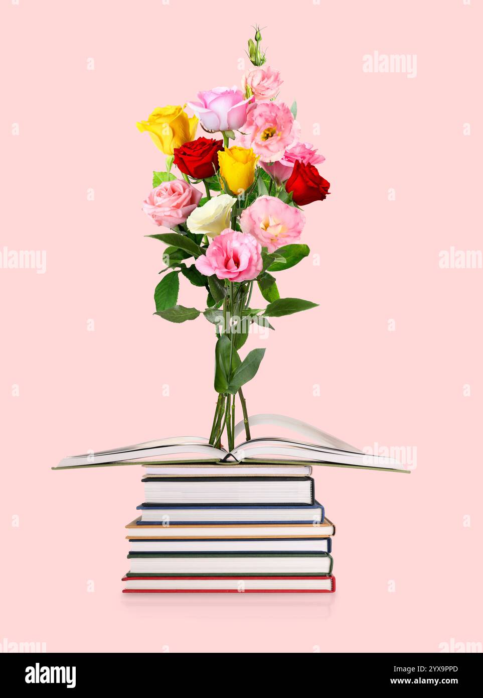 Stacked books and open one with beautiful flowers between pages on pink ...