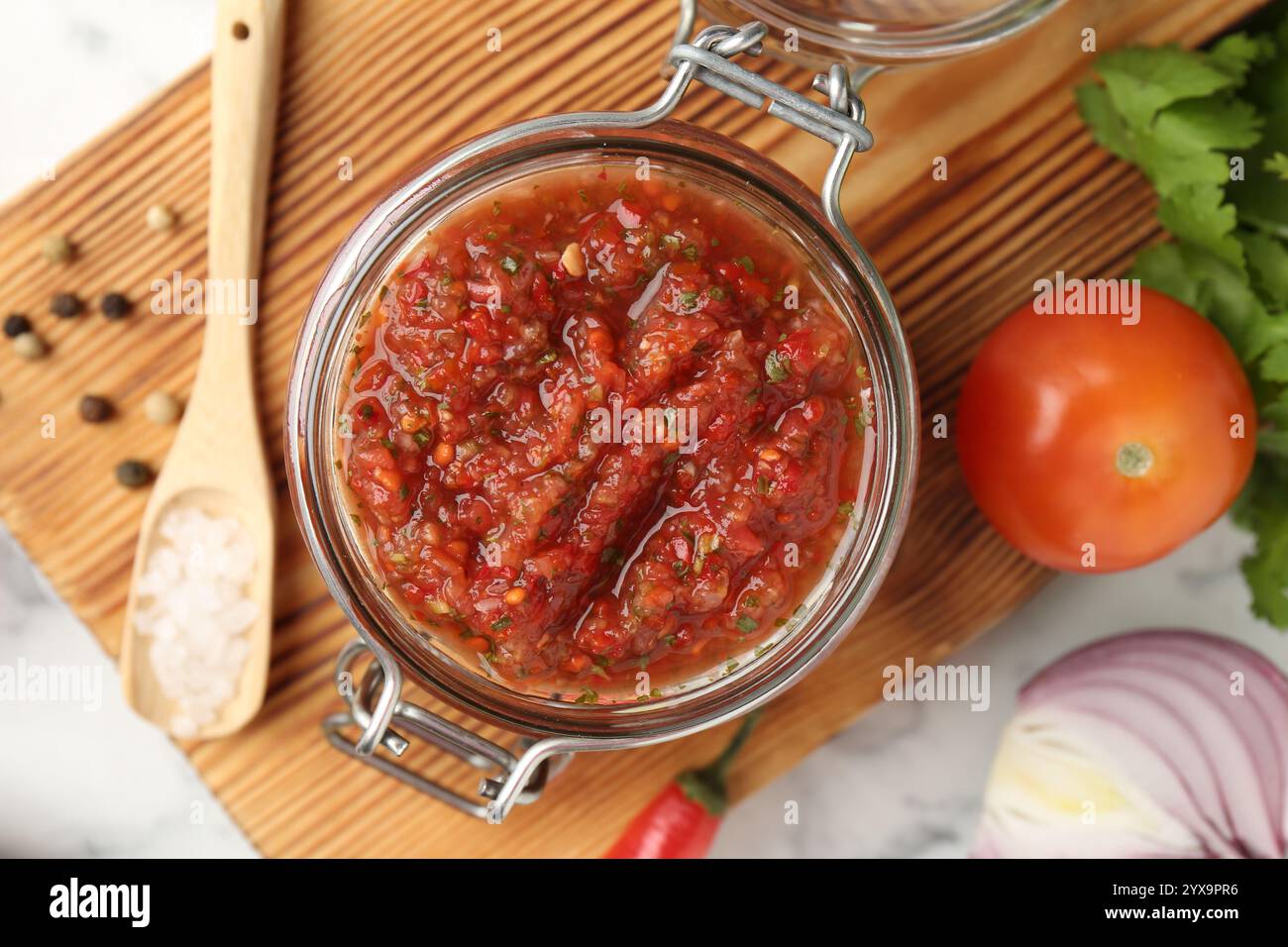 Spicy salsa and ingredients on white table, top view Stock Photo - Alamy