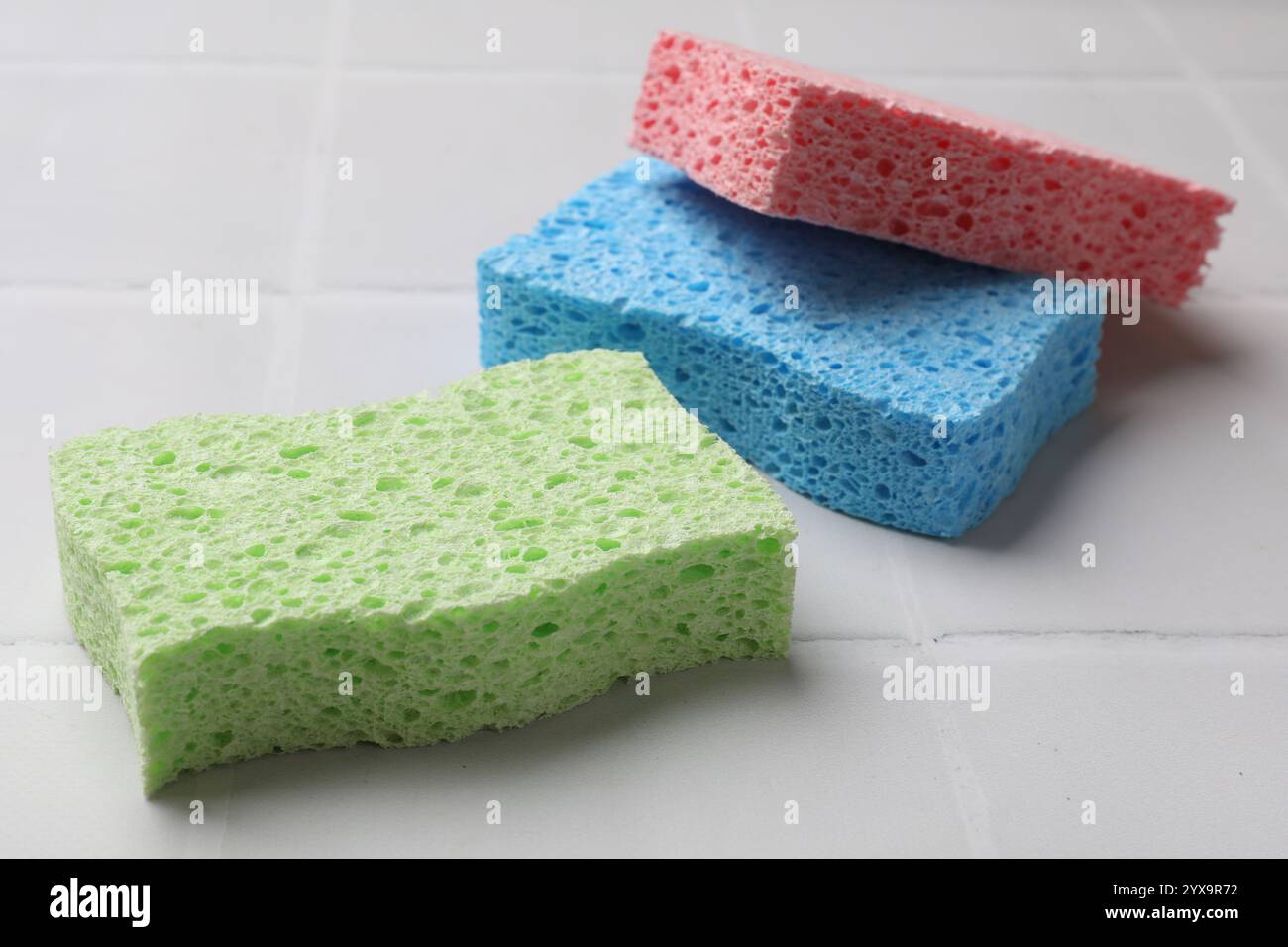 Soft sponges on white tiled table, closeup Stock Photo - Alamy