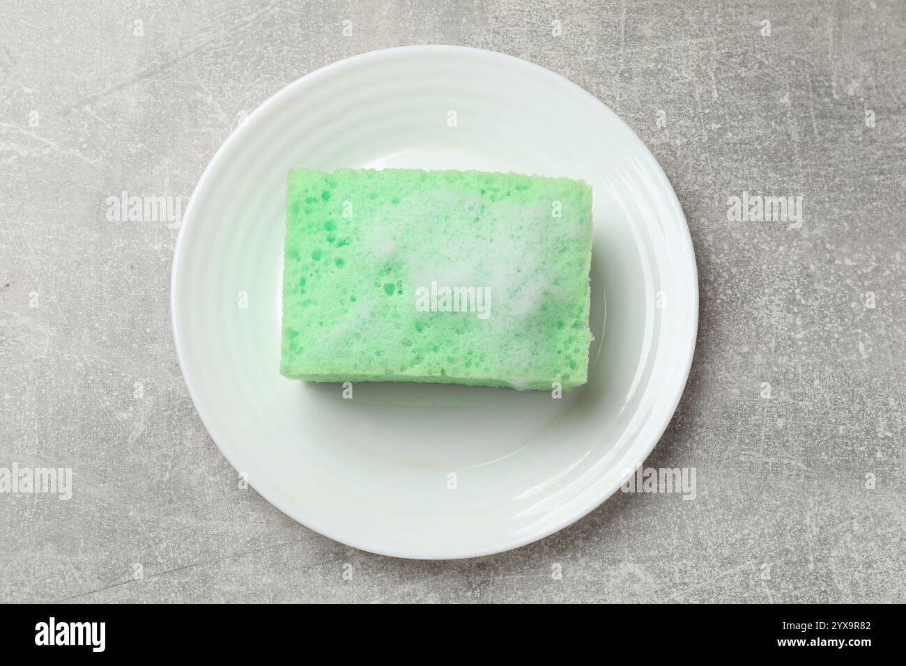 Sponge with foam and plate on light grey table, top view Stock Photo ...