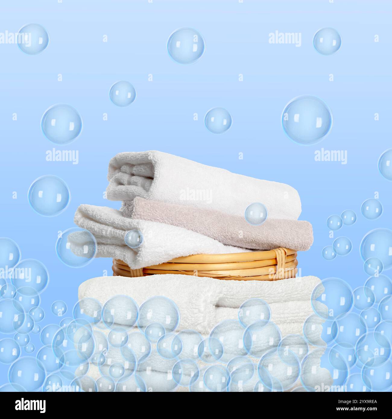 Stacked laundry and floating soap bubbles on light blue background Stock Photo - Alamy