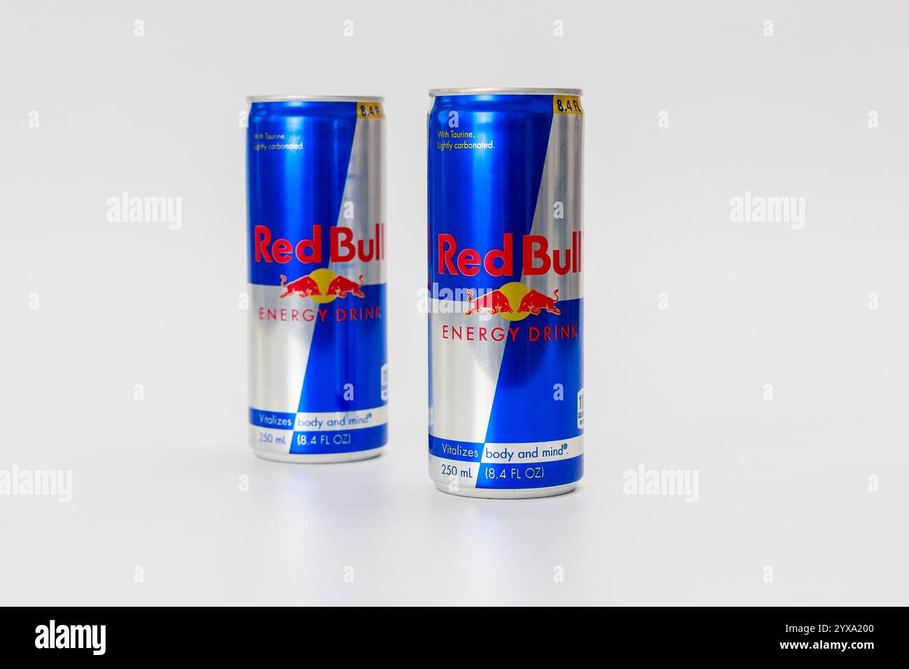 Bright blue energy drink cans placed on clean white surface ready to ...