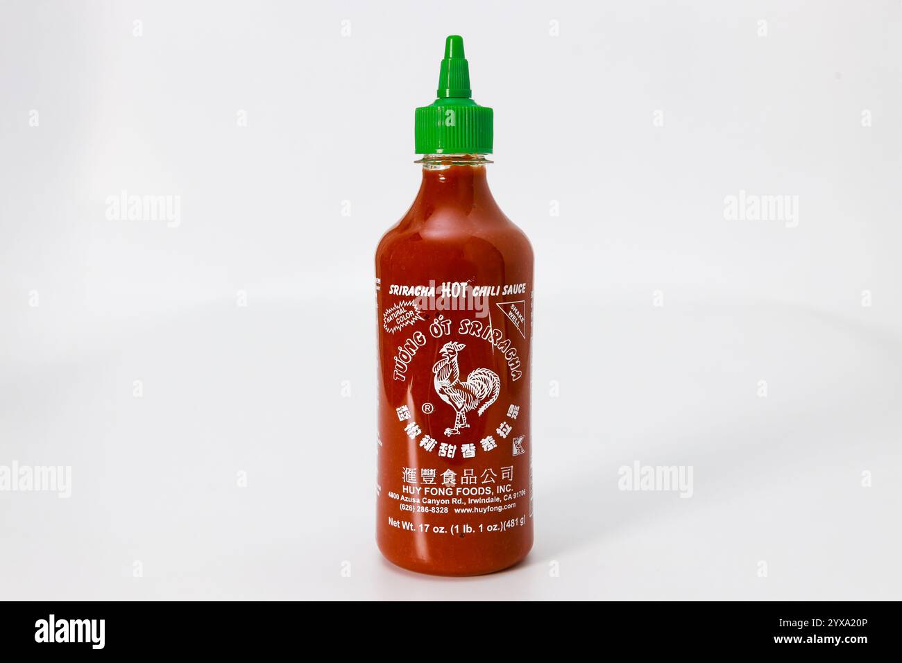 Hot chili sauce bottle featuring vibrant red sauce and green cap on ...