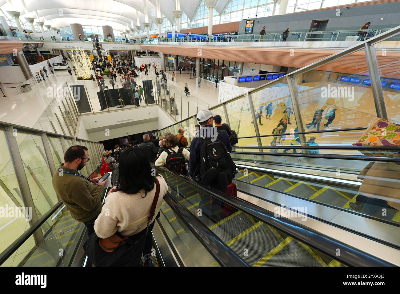 Travelers head down escalators after passing through the security ...