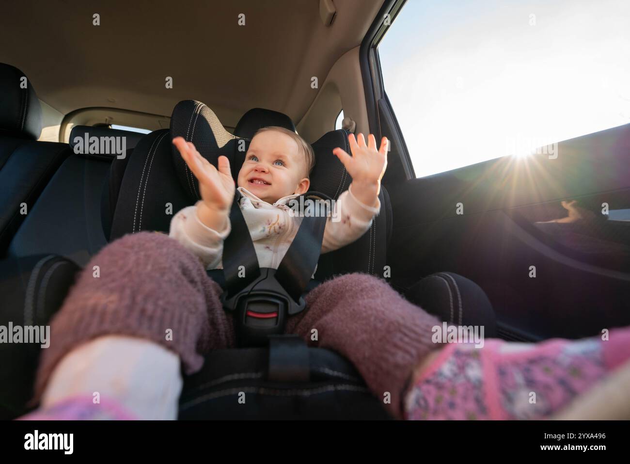 Happy baby clapping hands in car seat during road trip. Concept of safe ...