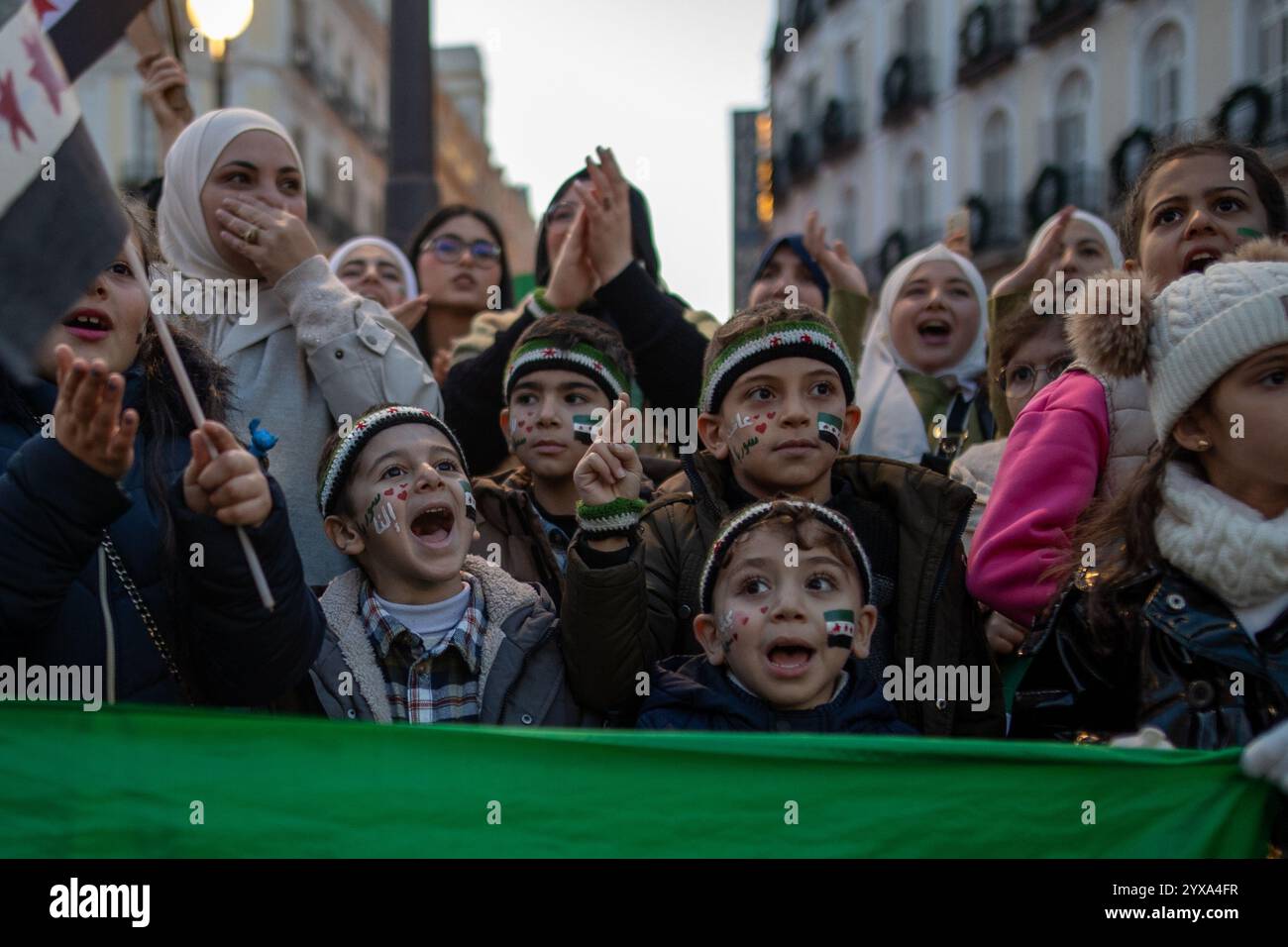 A group of children with painted faces participate in a rally. Syrian ...