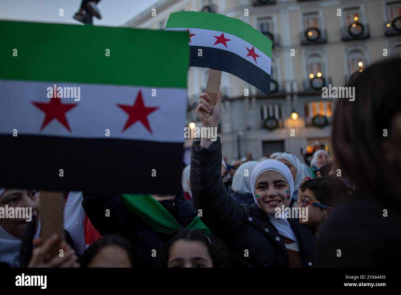 Protesters raise Syrian flags during a rally. Syrian residents in ...