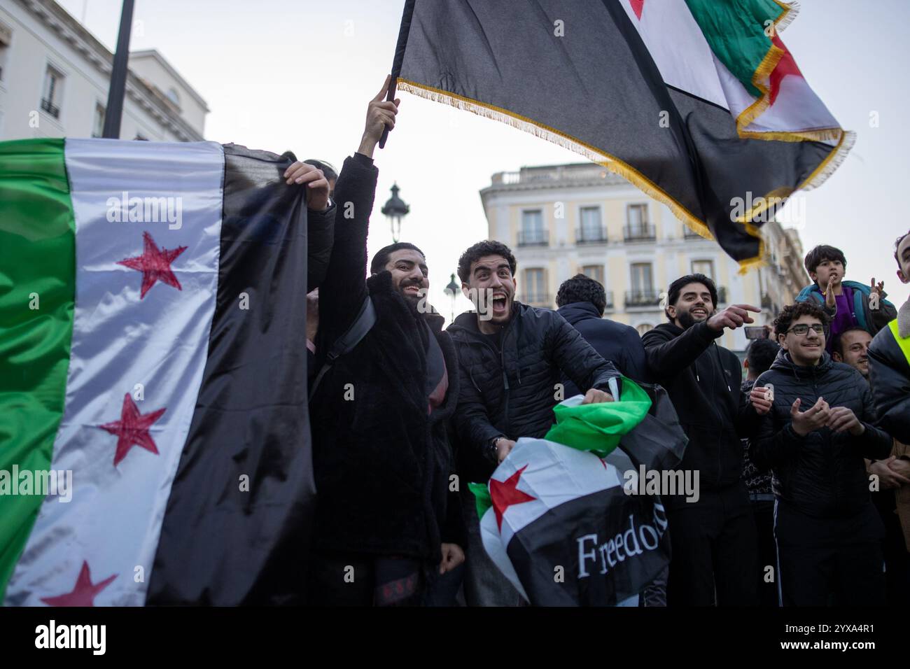 Protesters raise Syrian flags during a rally. Syrian residents in ...