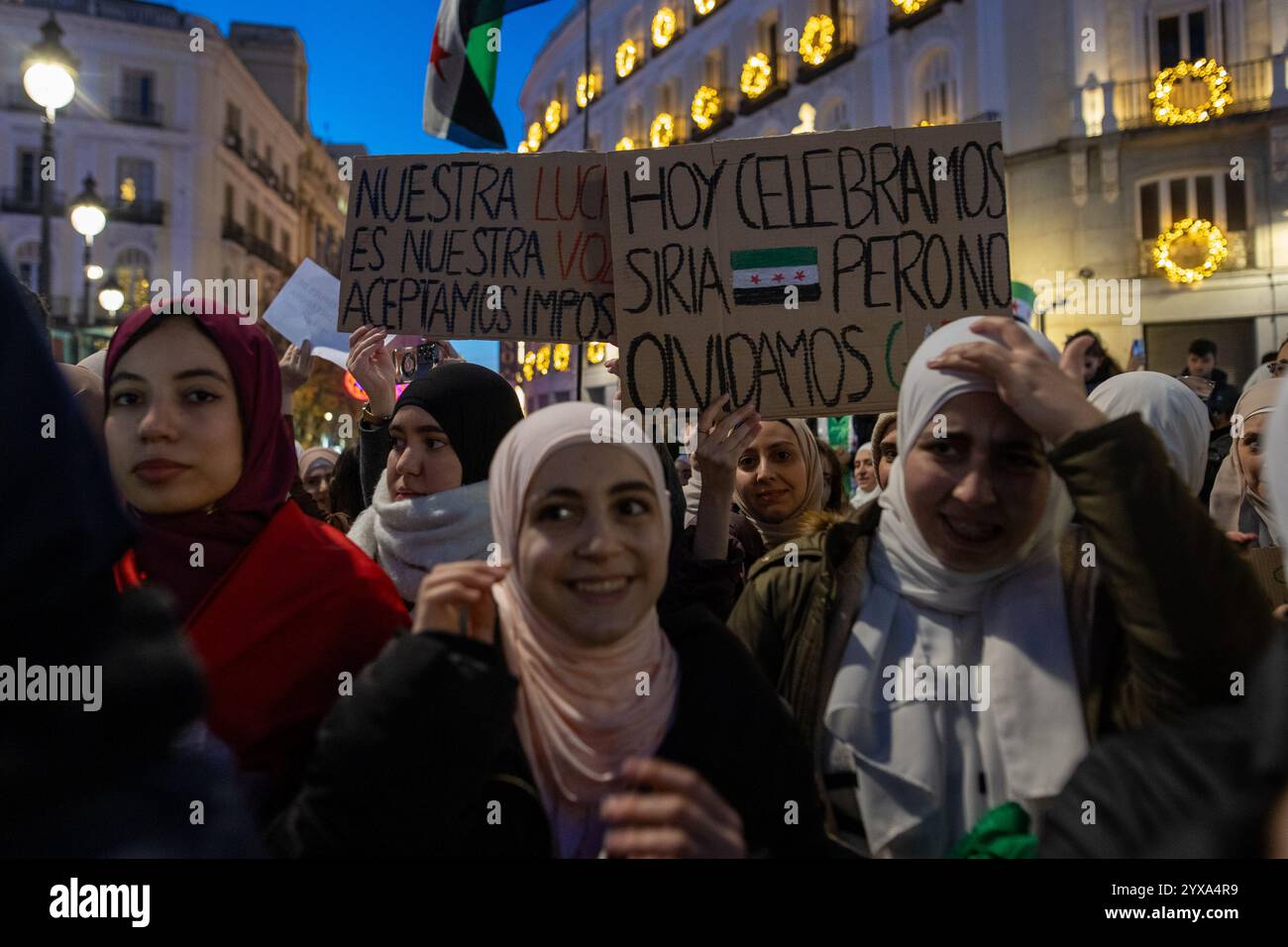 Protesters hold placards during a rally. Syrian residents in Madrid ...