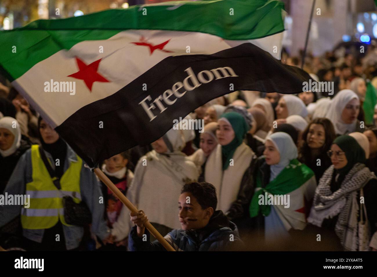 Madrid, Spain. 14th Dec, 2024. A boy raises the Syrian flag during a ...