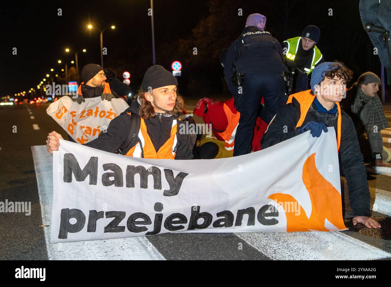 Climate activists block the road while holding a banner during the ...
