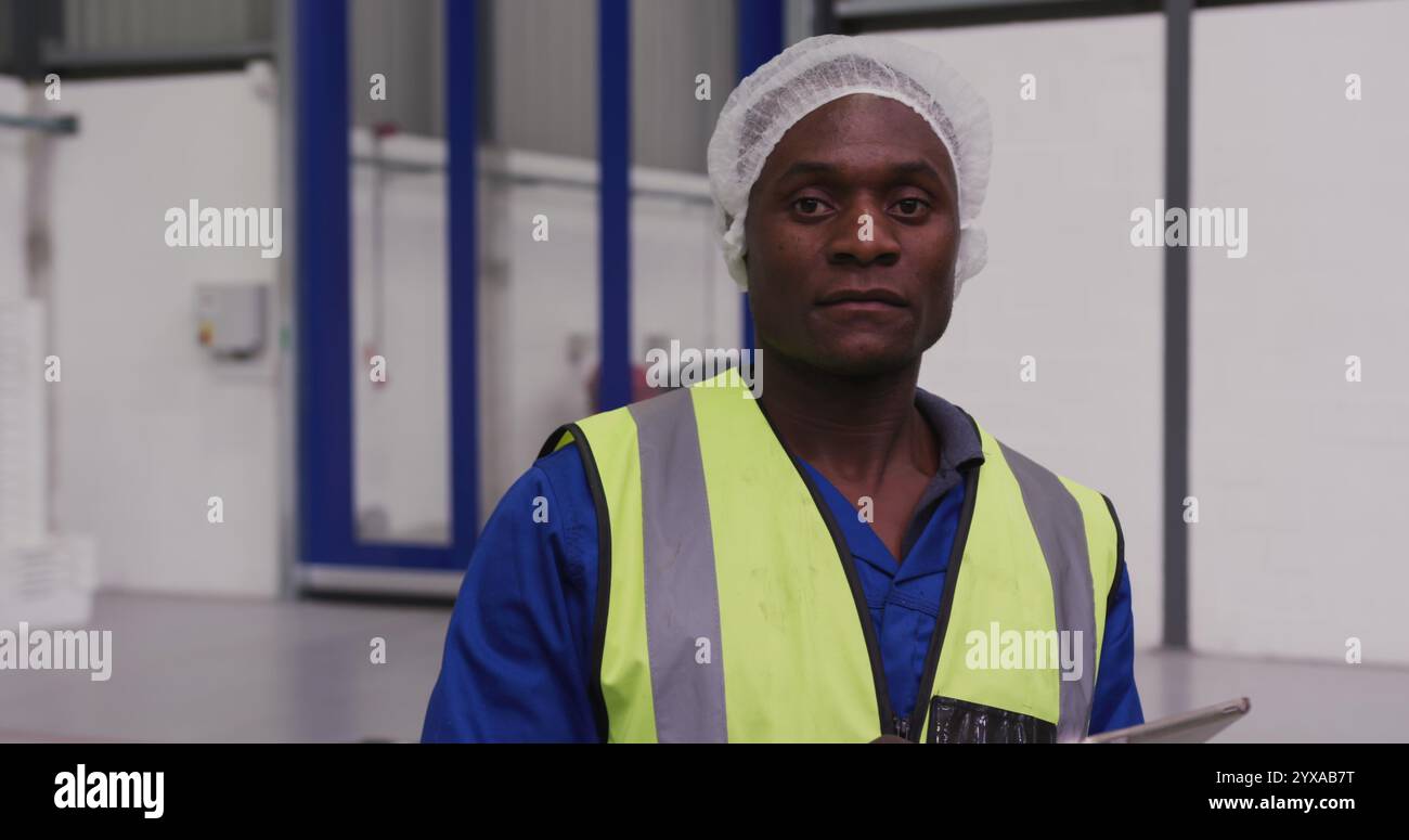 Warehouse worker in safety vest holding clipboard, ensuring quality ...