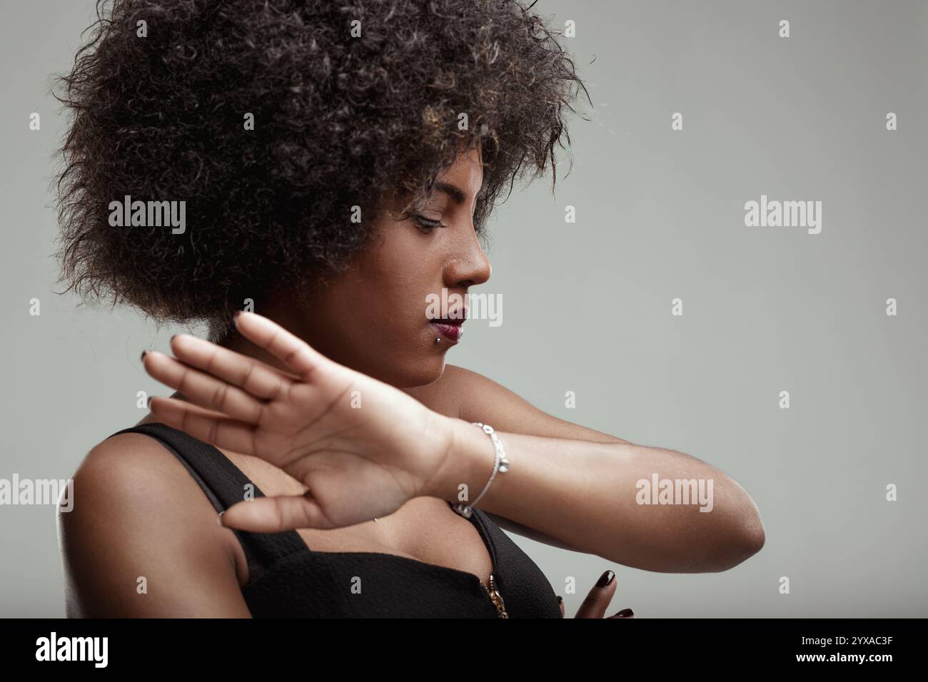 Studio portrait of a young latin american woman with curly hair making ...
