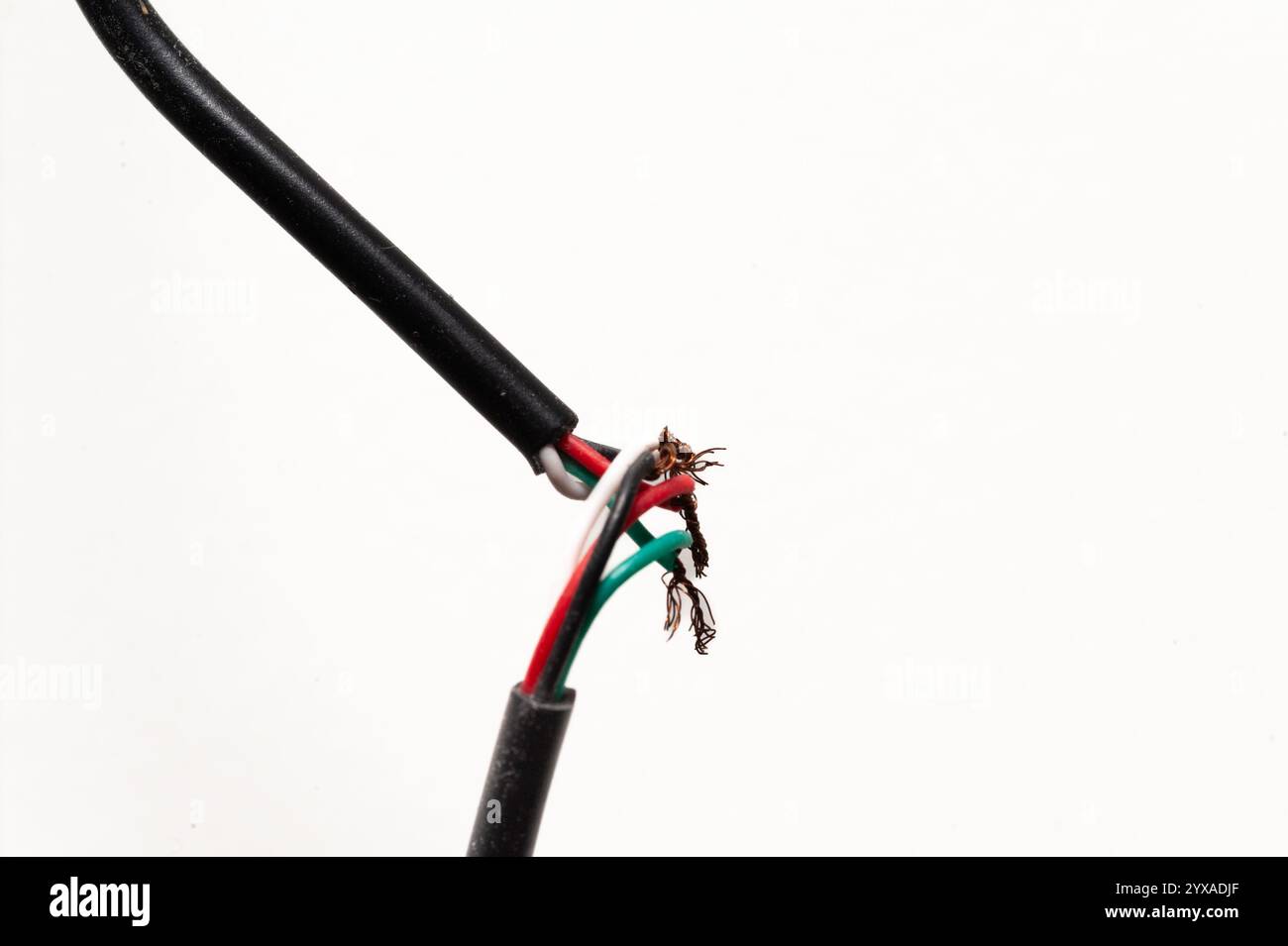 A wire is cut in half and has a green, red, and black color. The wire ...