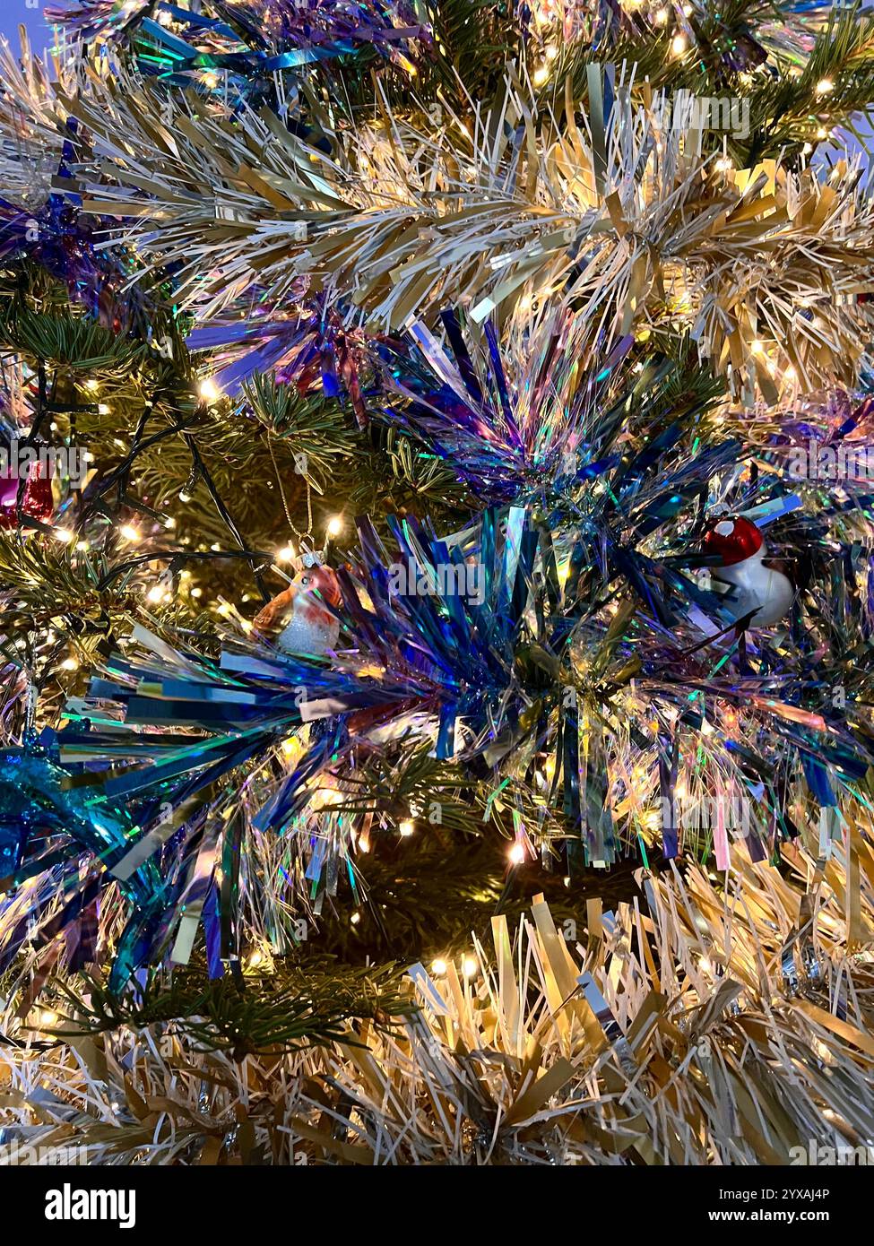 Christmas tree decorated with sparkly tinsel decorations. Close up ...