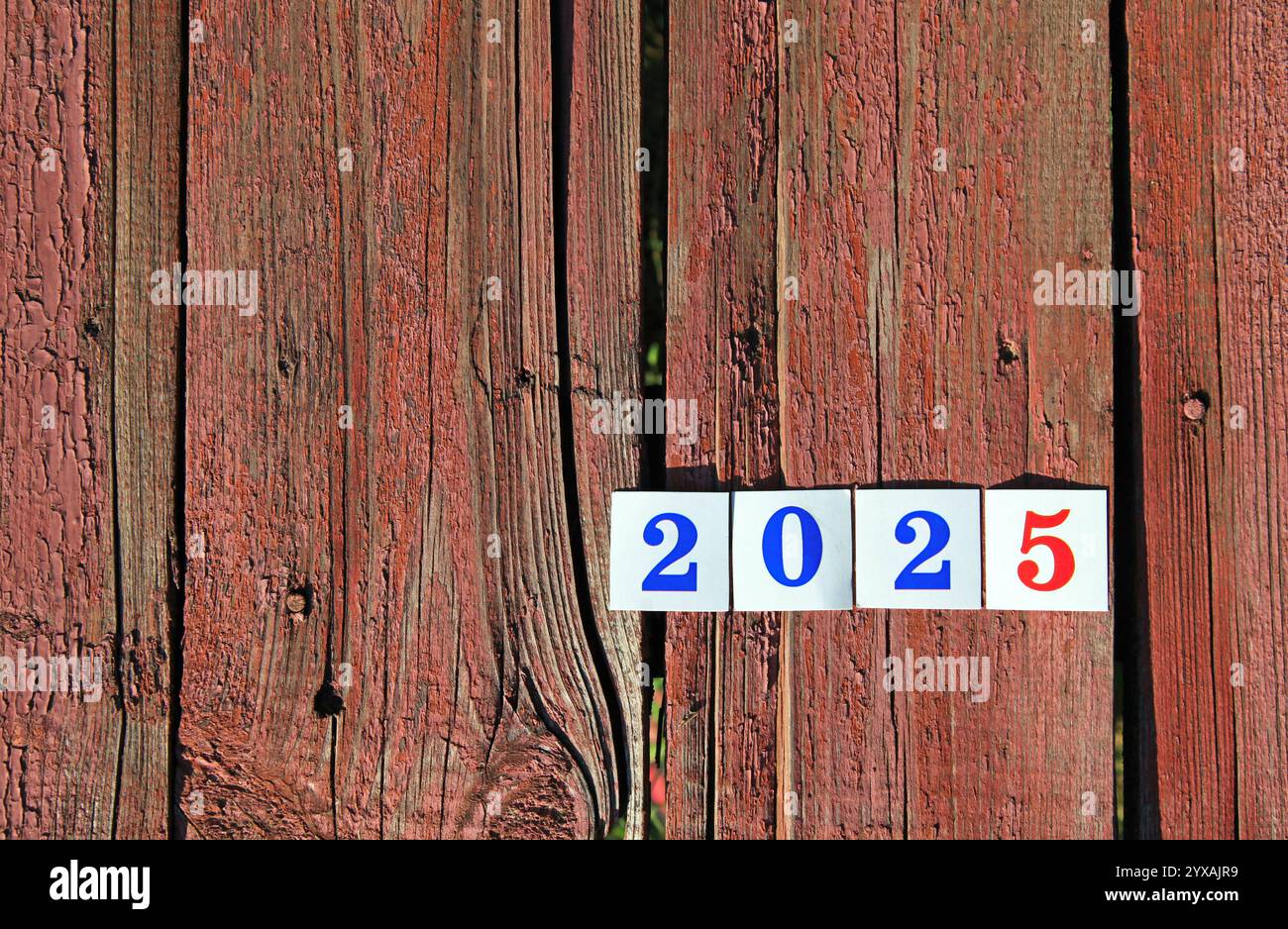 Numbers of 2025 year. Paper square numbers on the wooden fence ...