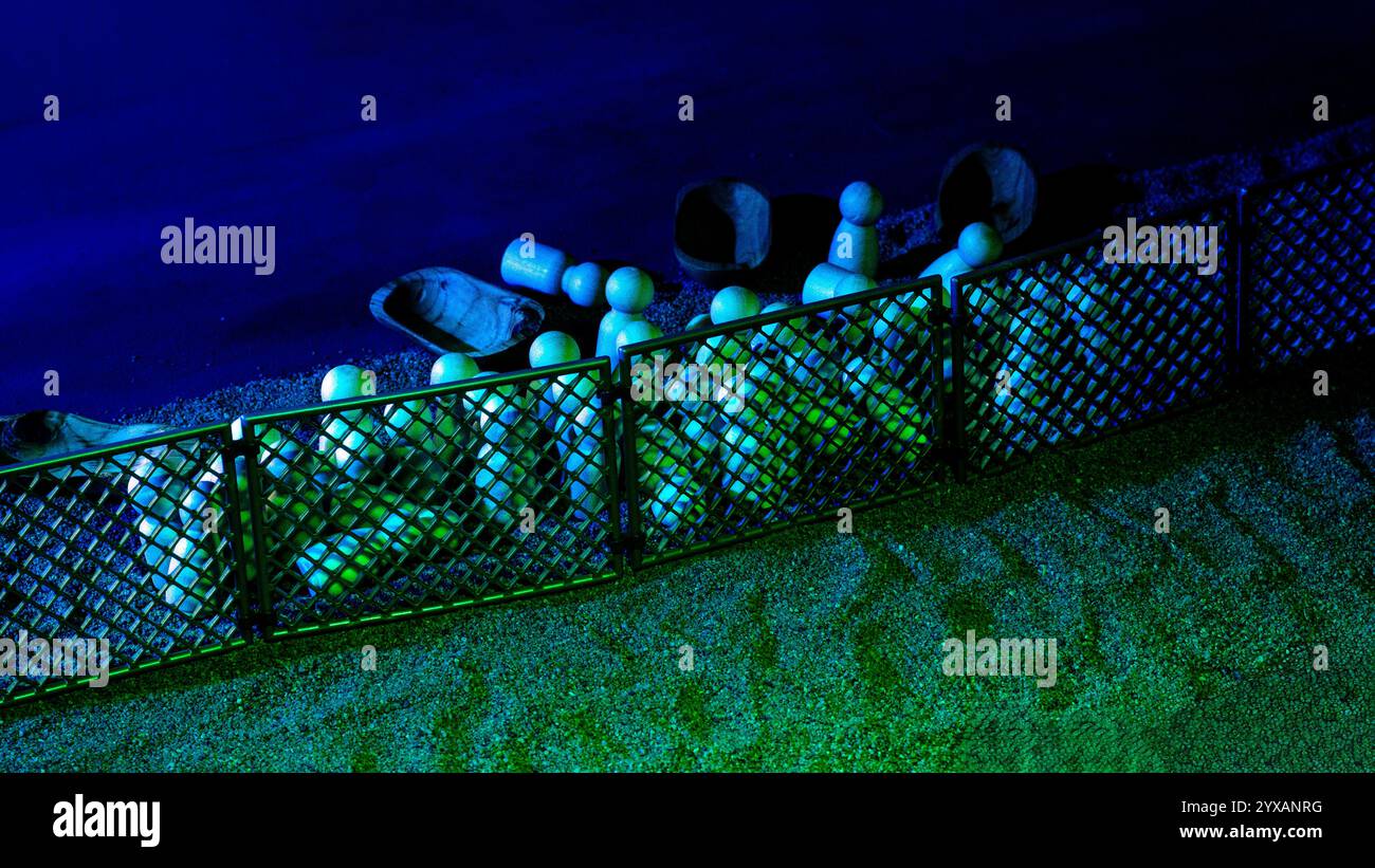 Wooden Figures Behind a Fence Under Blue-Green Lighting Stock Photo - Alamy