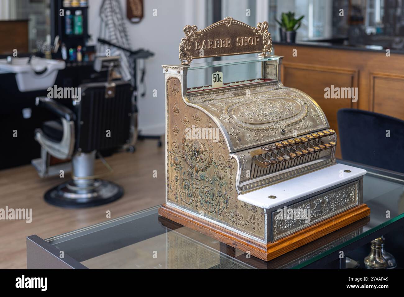 An ornate vintage cash register displayed in a traditional barber shop ...