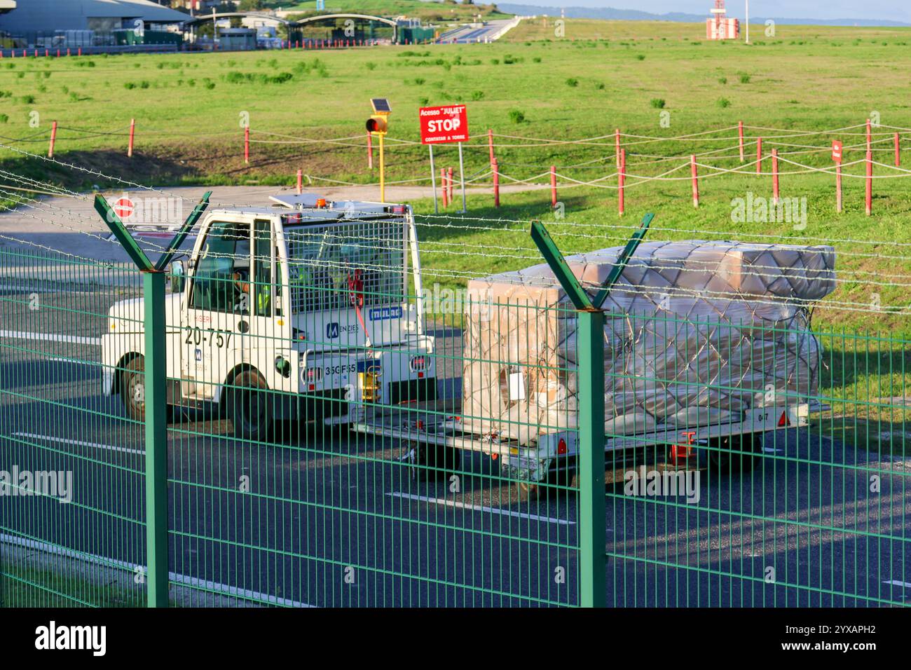 Airport tow truck pulling cargo trailer at lisbon humberto delgado ...