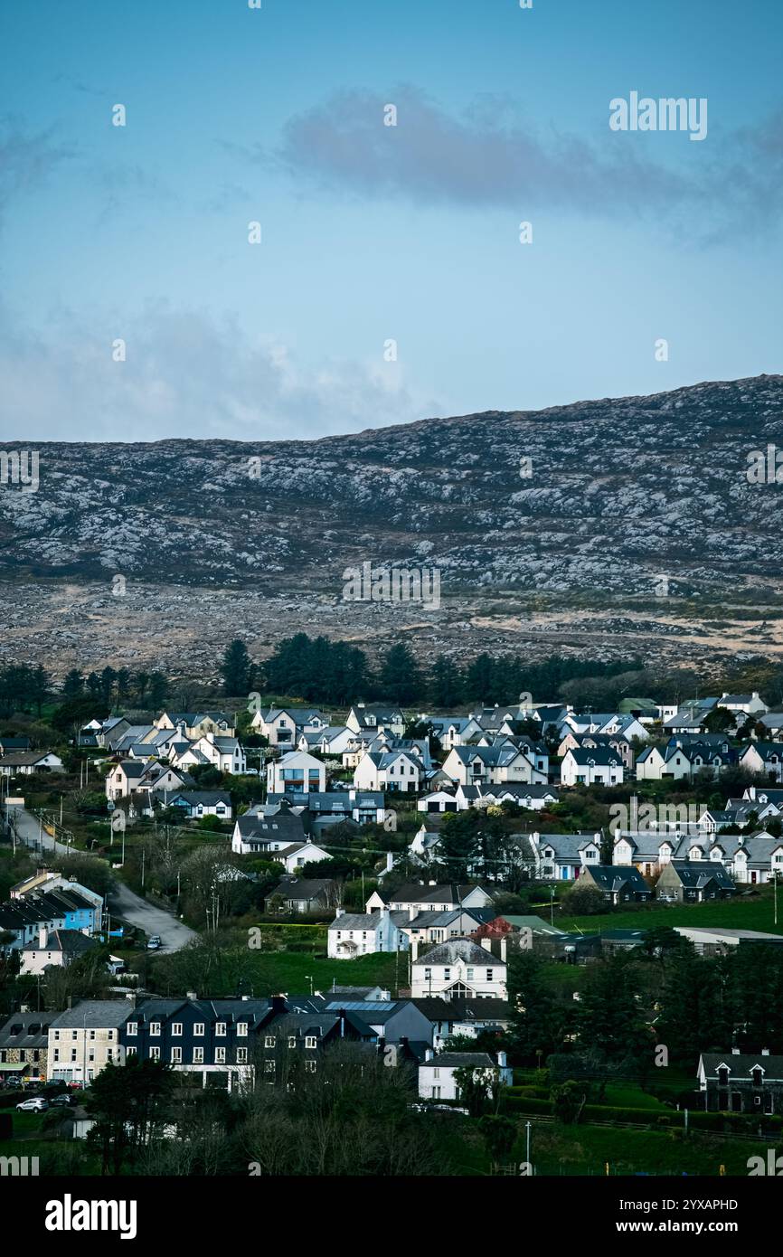 A hillside dotted with white houses, many with black roofs, sits below ...