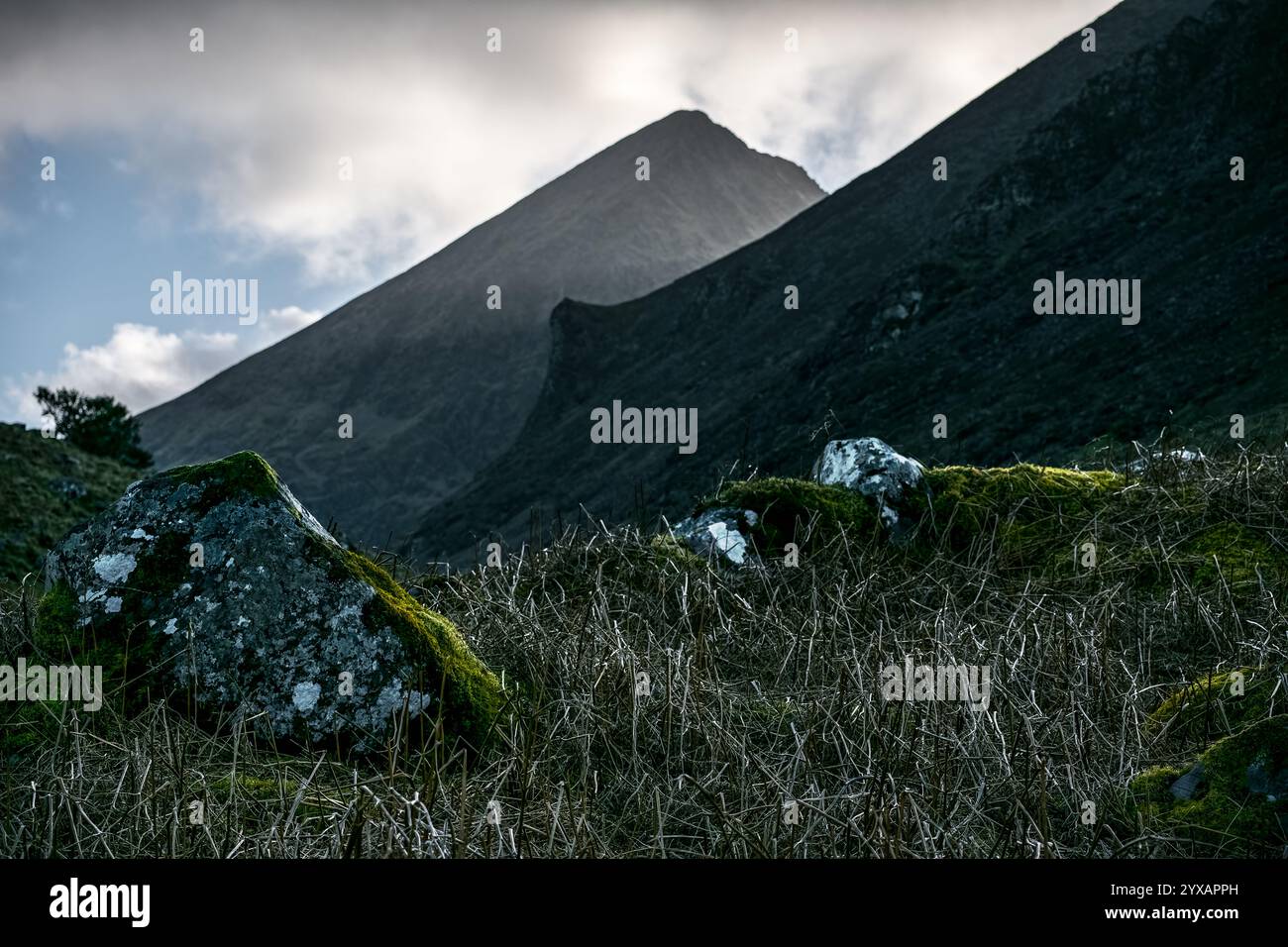 The photograph captures a mountainous landscape. A large mountain forms ...