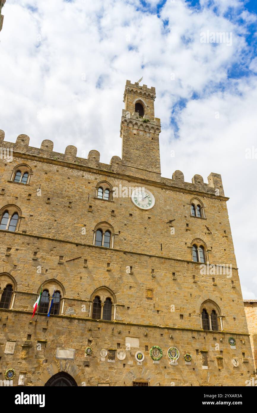 Clock and tower of the historic town hall in Volterra, Italy Stock ...