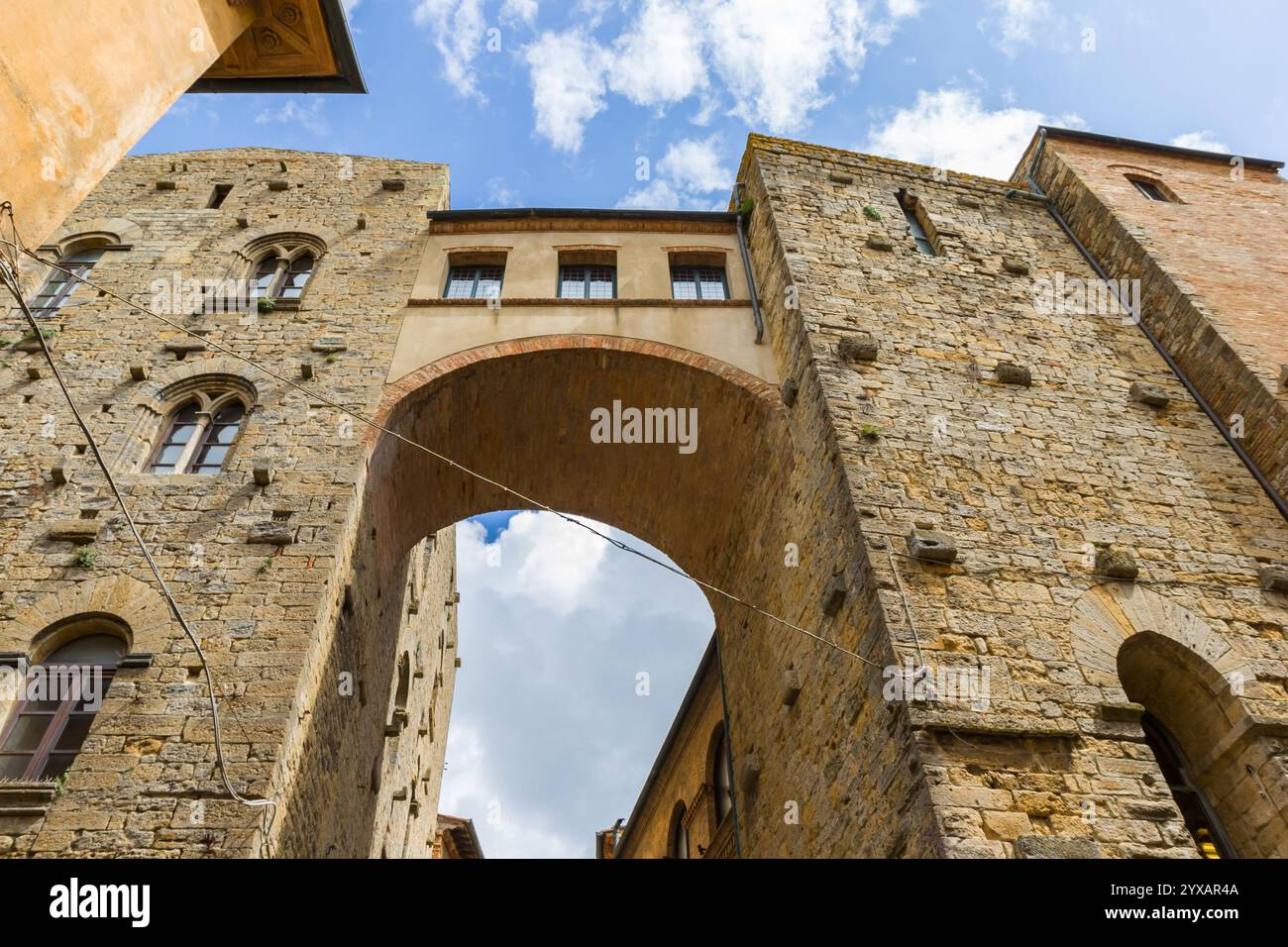 Bridge between two historic buildings in Volterra, Italy Stock Photo ...