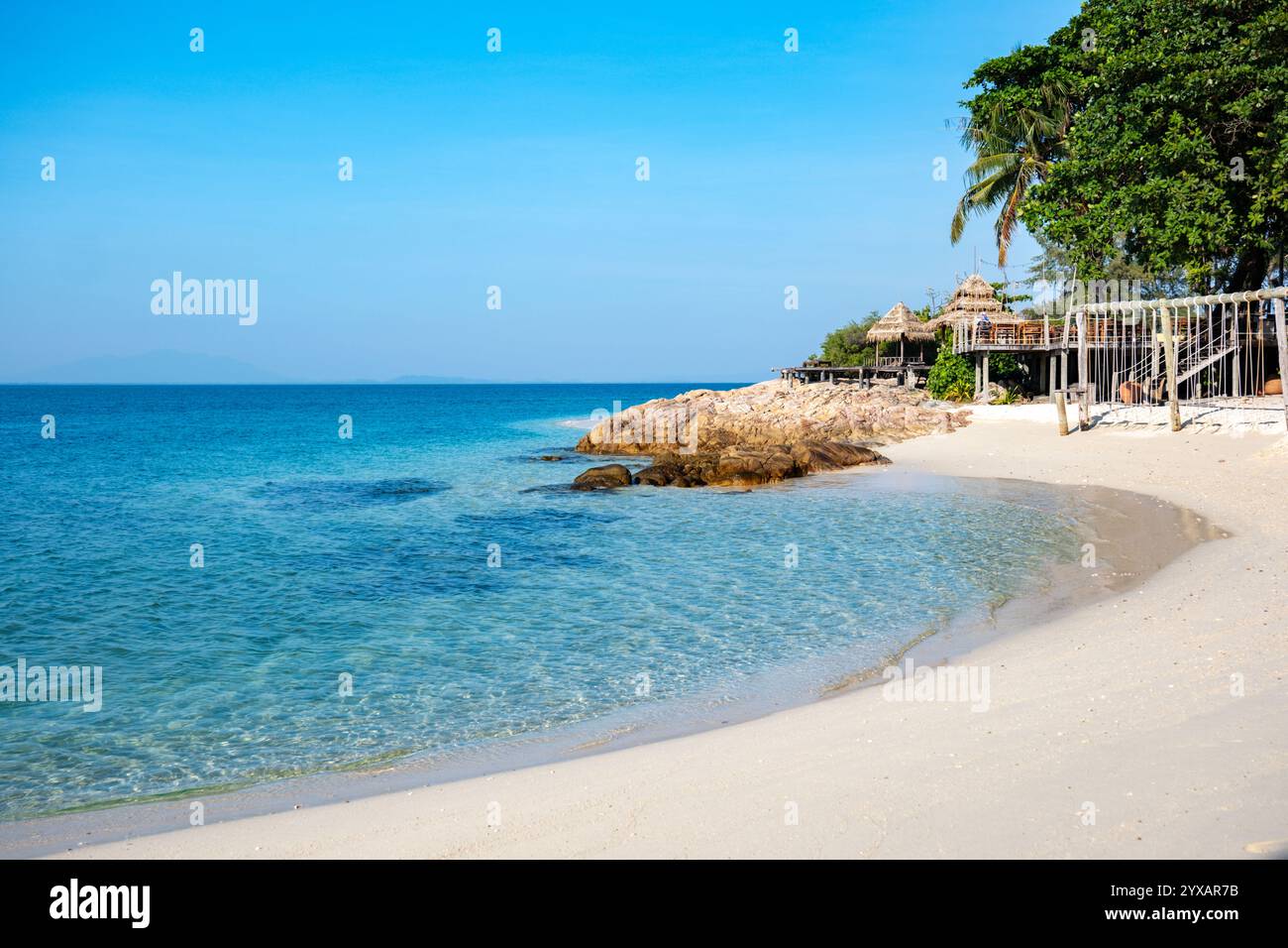 Crystal-clear waters gently lap the pristine sandy beach of Koh Munnork Island, a hidden gem in ...