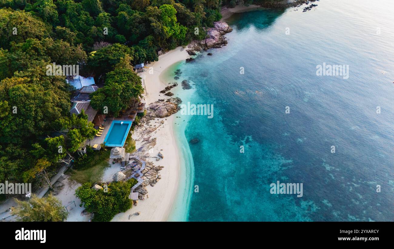 Lush greenery frames the pristine beach of Koh Munnork Island, where gentle waves kiss the shore ...