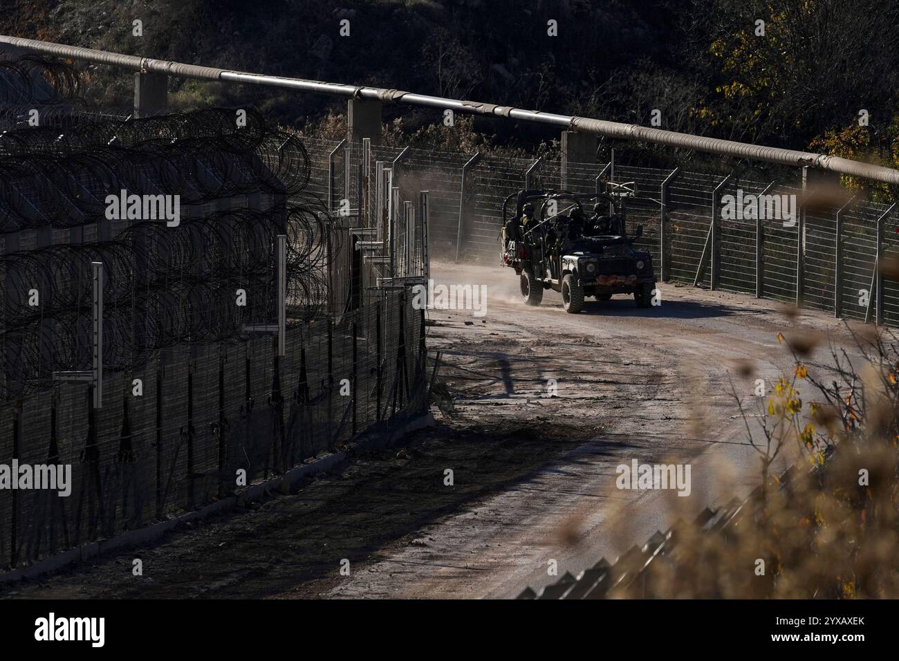 Israeli soldiers stand on an armoured vehicle before crossing the ...