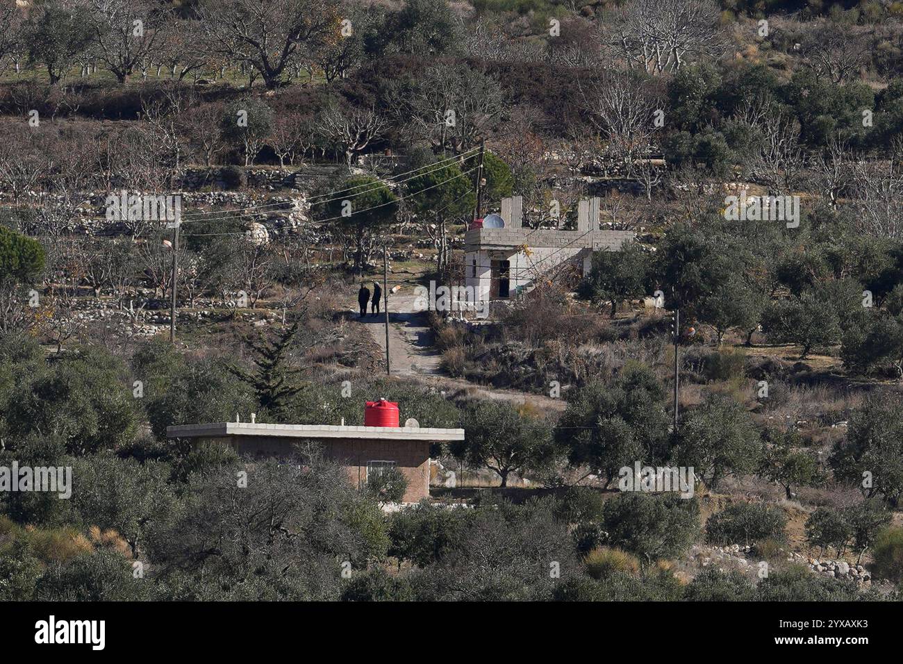 Civilians stand next a house near the so-called Alpha Line that ...