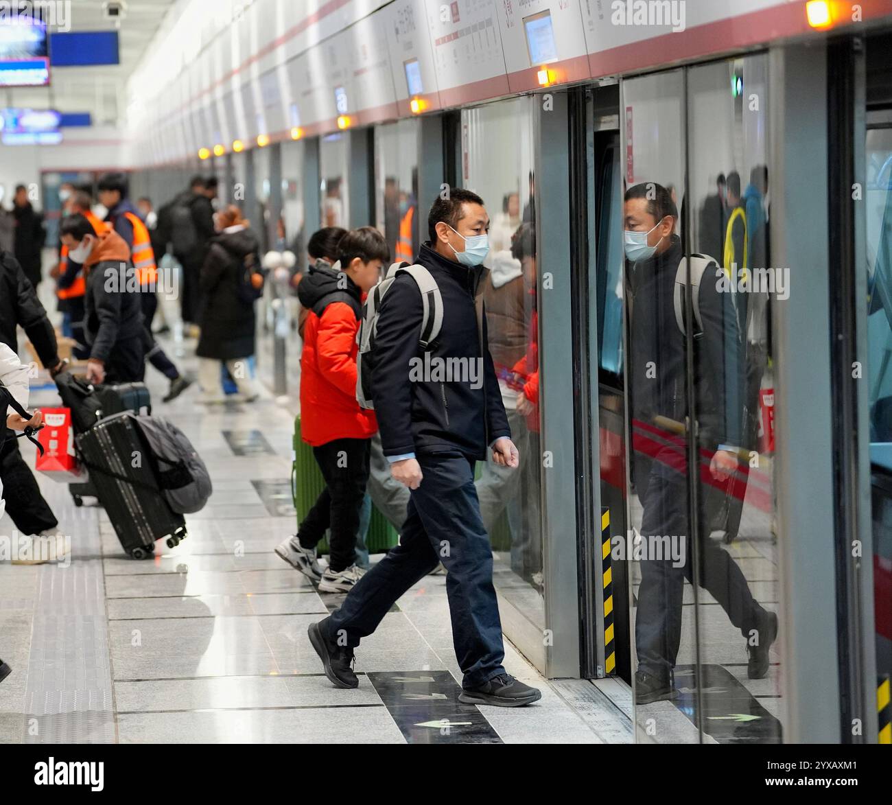 Beijing, China. 15th Dec, 2024. Passengers board a train of Subway Line ...