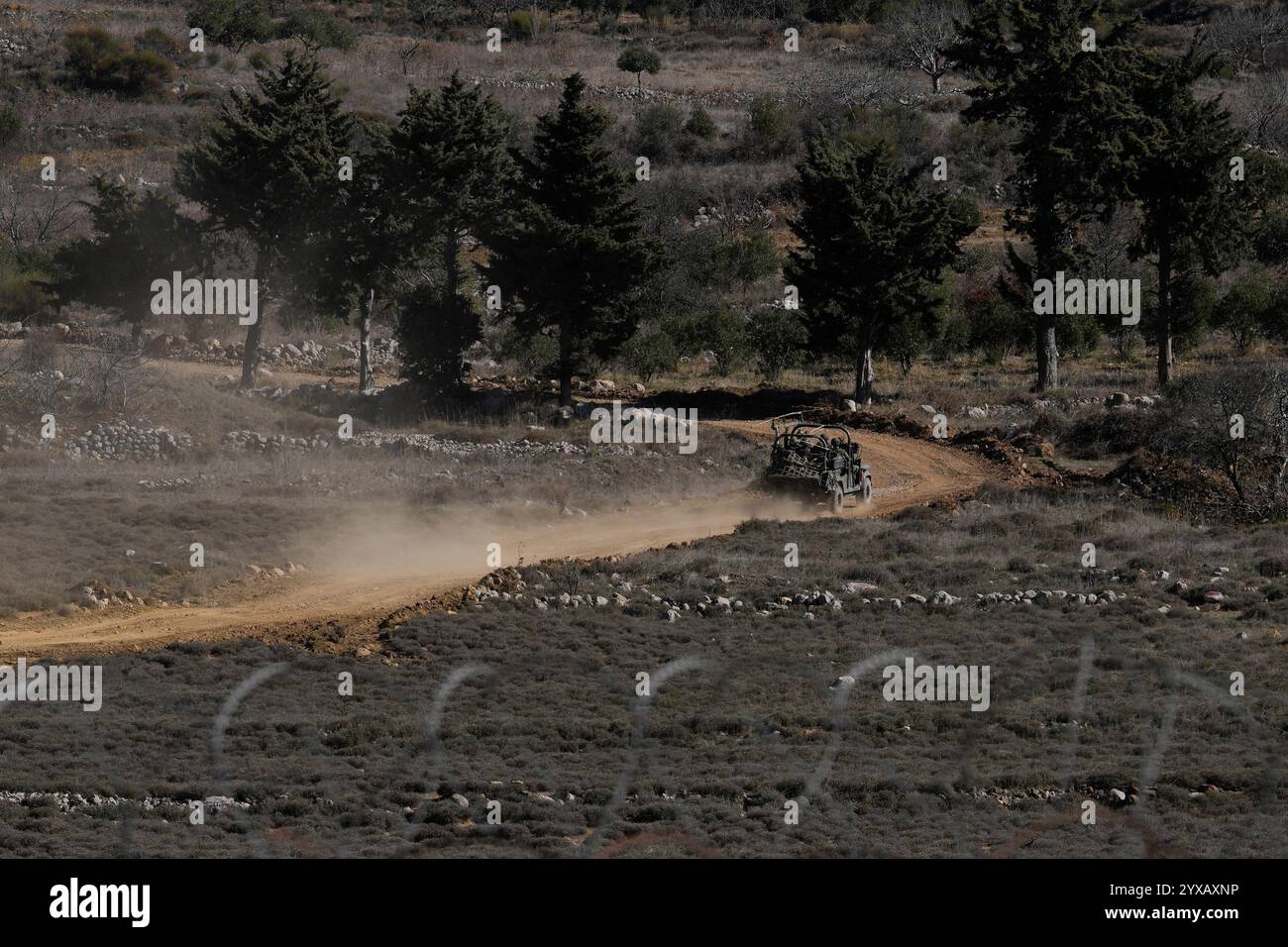 An Israeli armoured vehicle crosses the security fence moving towards ...