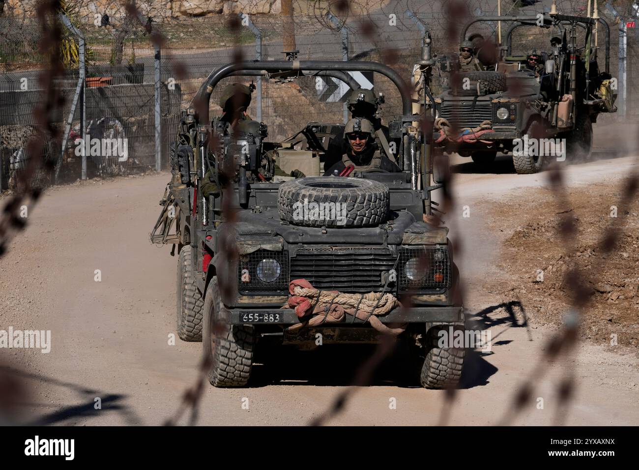 Israeli soldiers stand on armoured vehicles after crossing the security ...